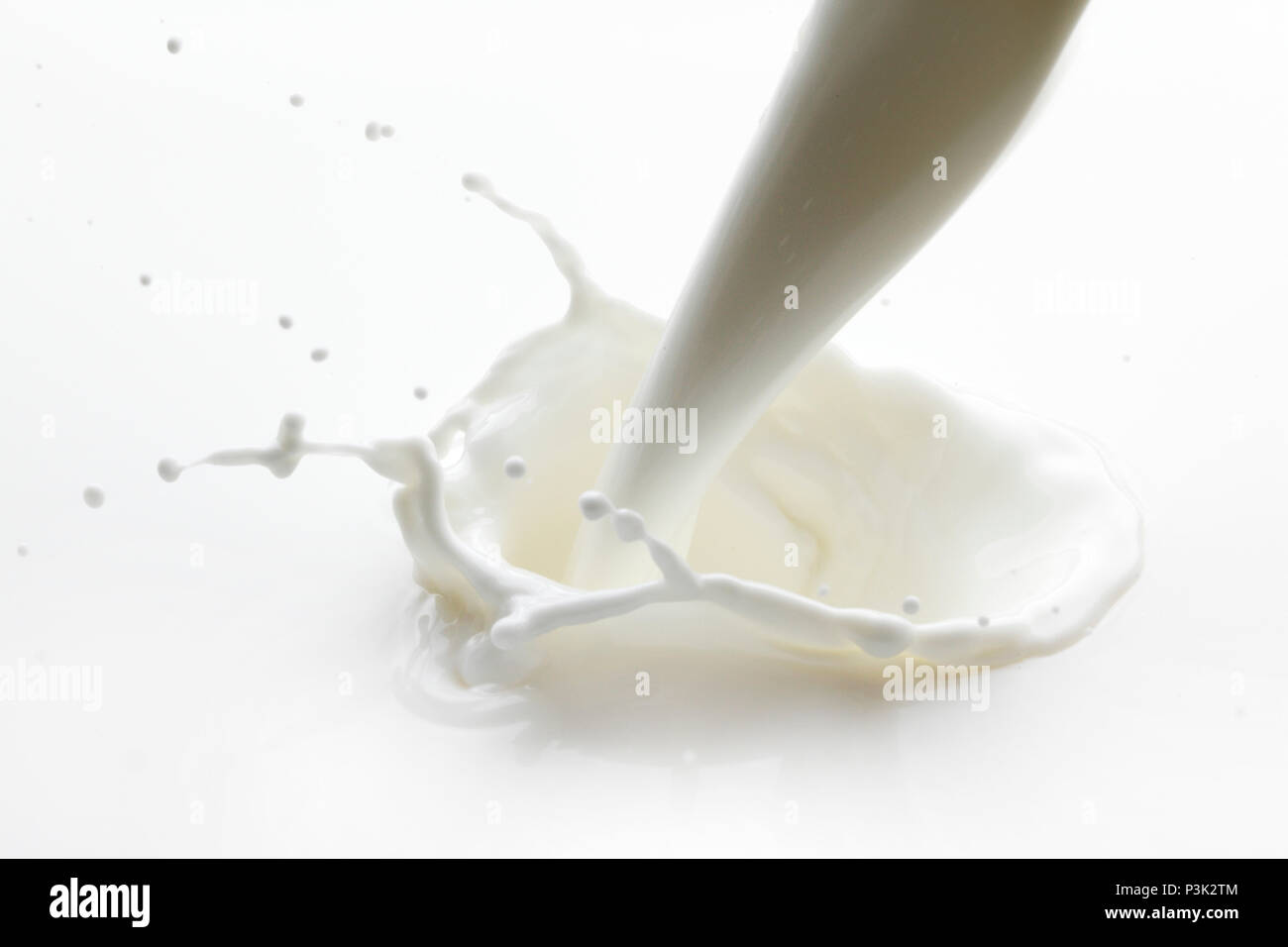 Pouring milk splash isolated on white background macro Stock Photo - Alamy