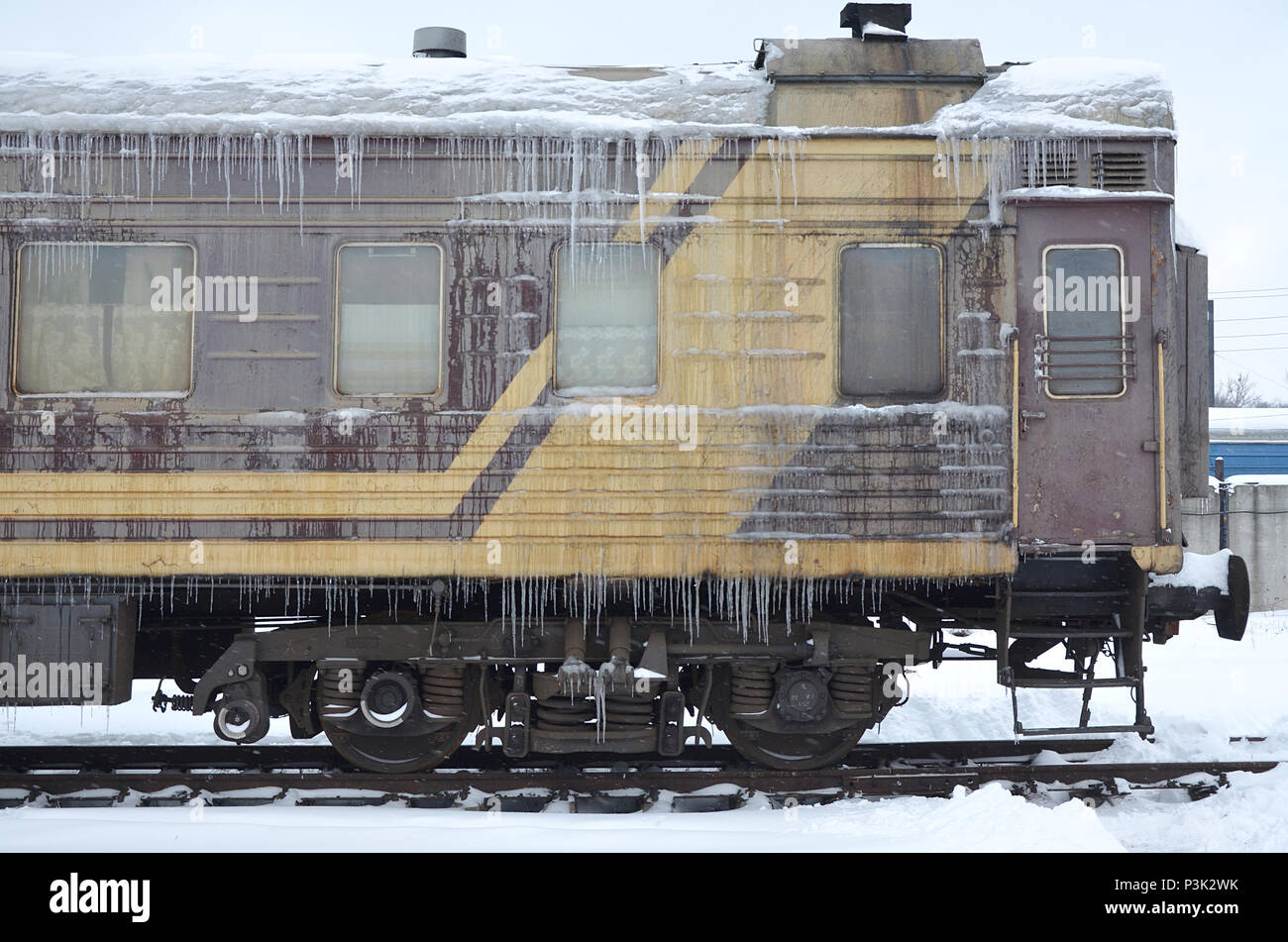 Detailed photo of a frozen car passenger train with icicles and ice on ...