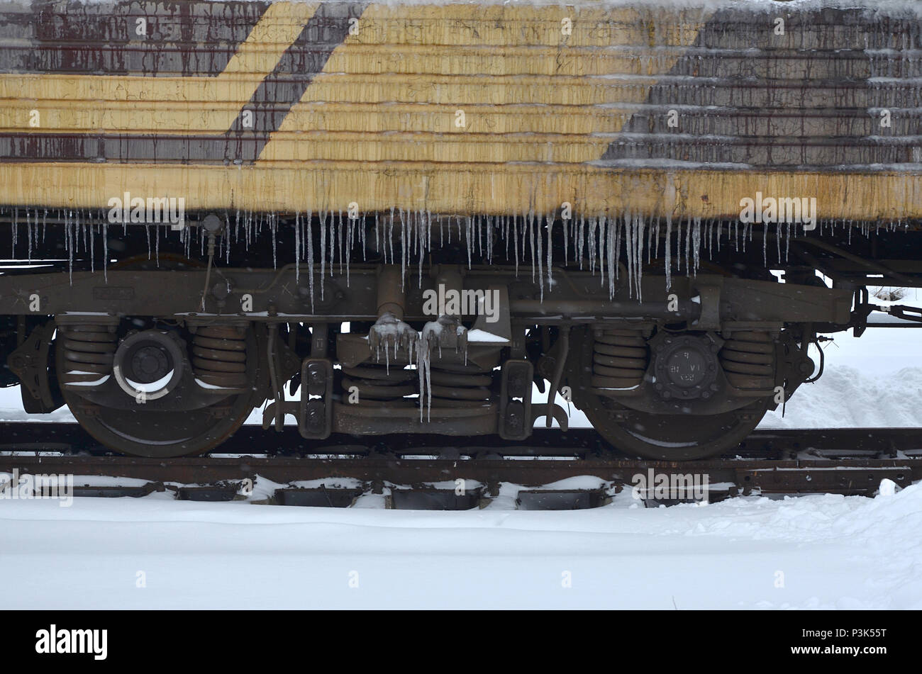 Detailed photo of a frozen car passenger train with icicles and ice on ...
