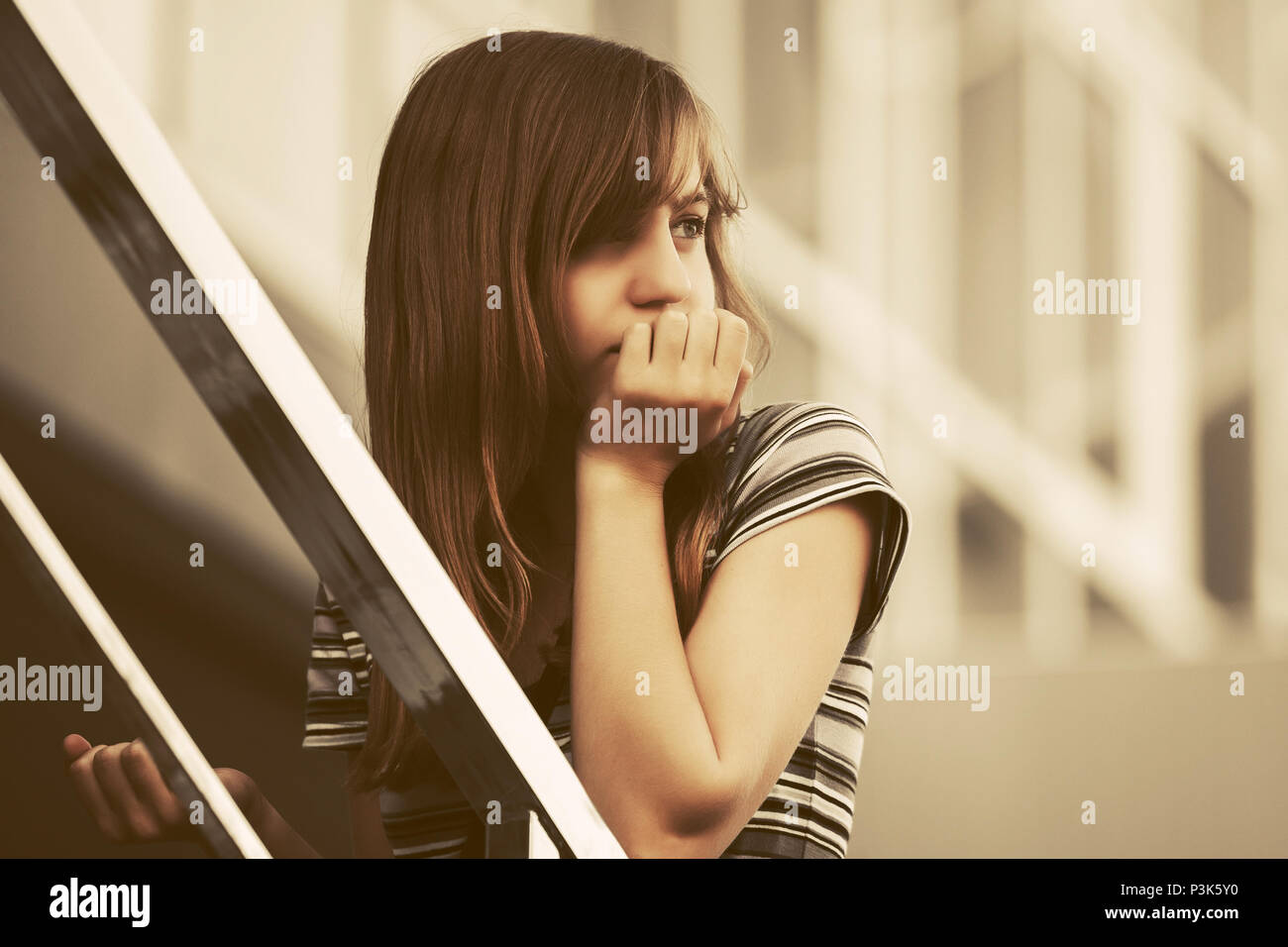 Sad teen girl on steps against a school building. Stylish fashion model ...