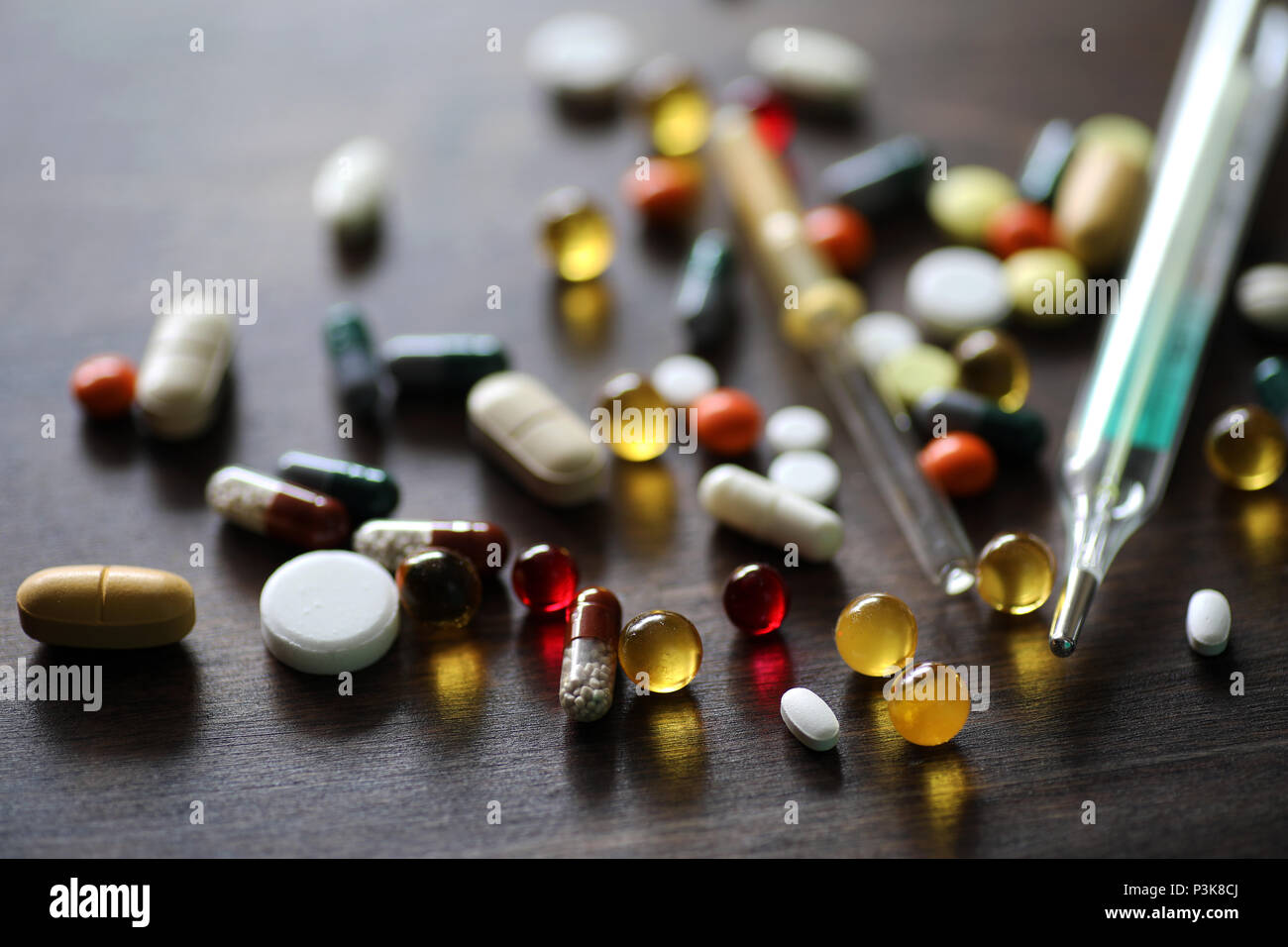 Different colored medications and tablets on a wooden texture table ...