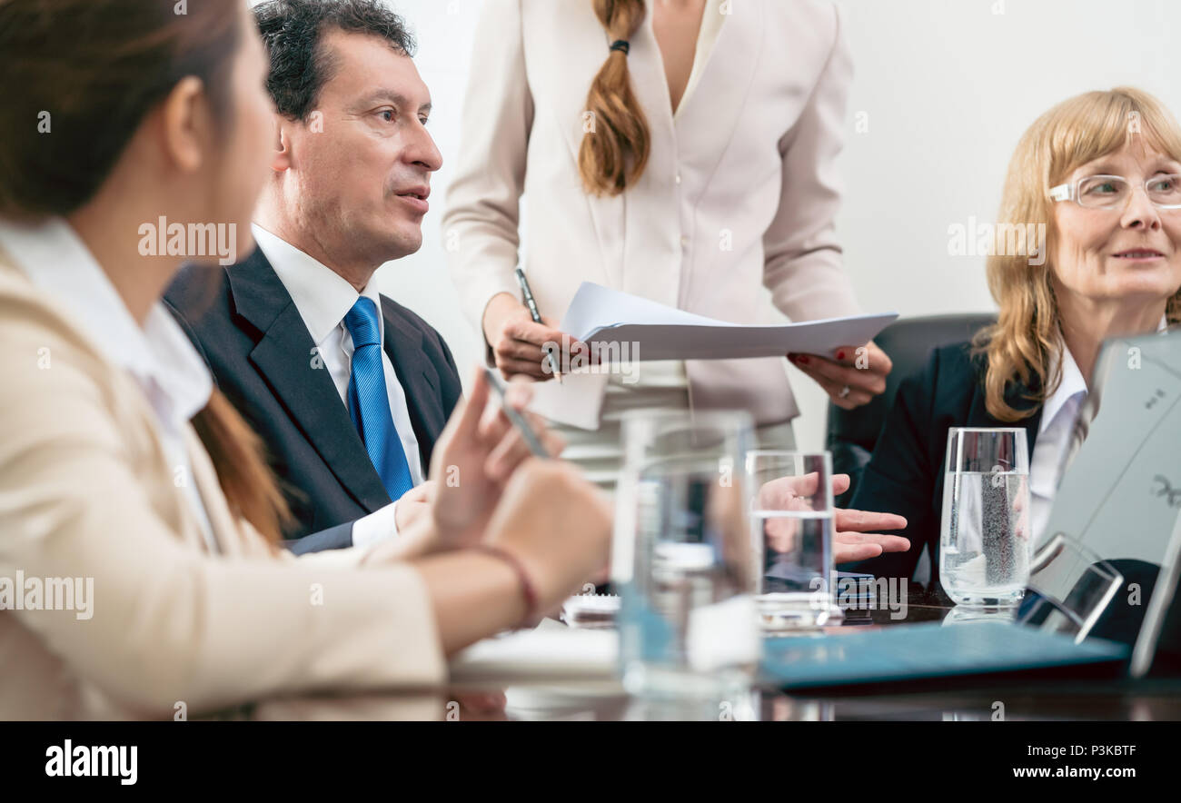 Middle-aged skilled manager cooperating with his colleagues Stock Photo ...