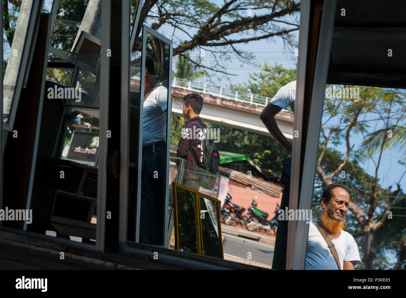 Mawlamyaing, Myanmar, passers-by are reflected in a shop window Stock ...