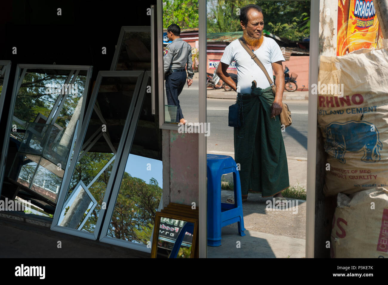 Mawlamyaing, Myanmar, passers-by are reflected in a shop window Stock ...