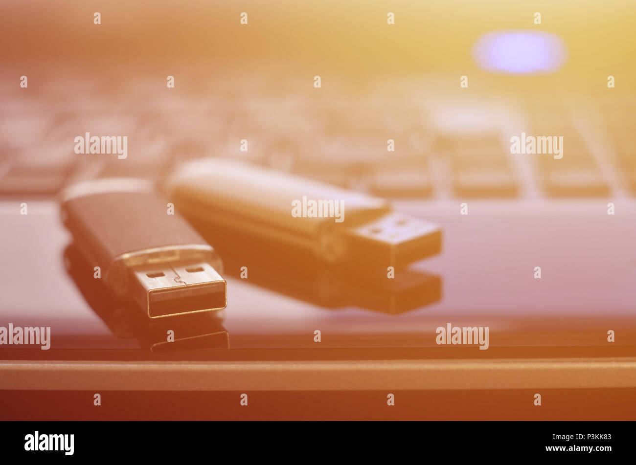 USB flash cards lying on black laptop case in front of his keyboard ...