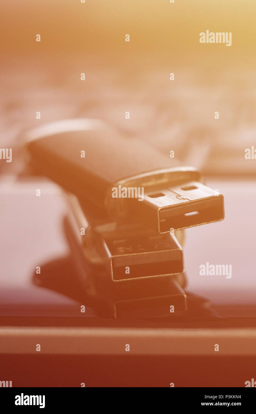 USB flash cards lying on black laptop case in front of his keyboard ...