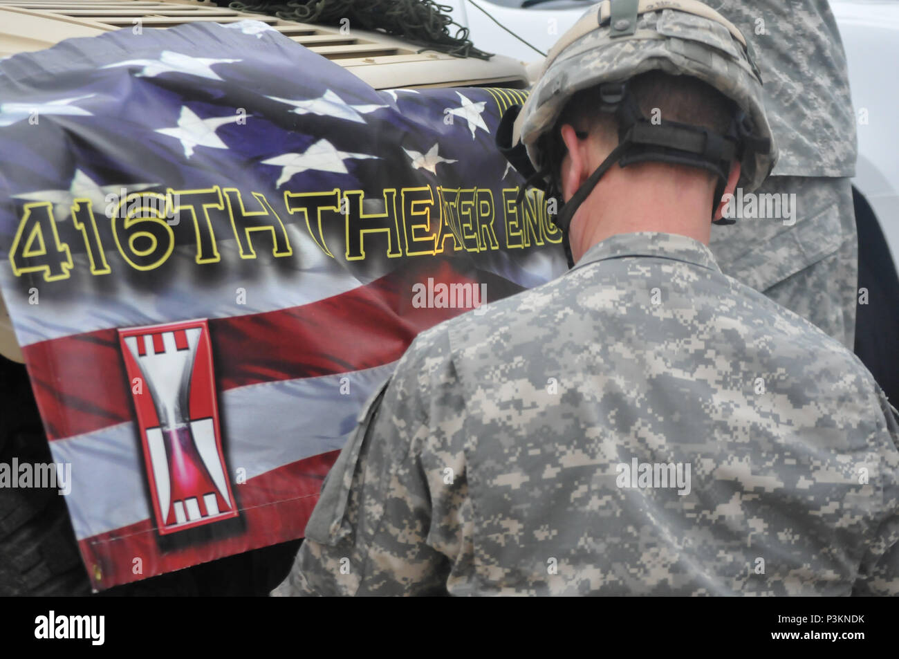 Master Sgt. Keith Clark affixes the banner for the 416th Theater ...