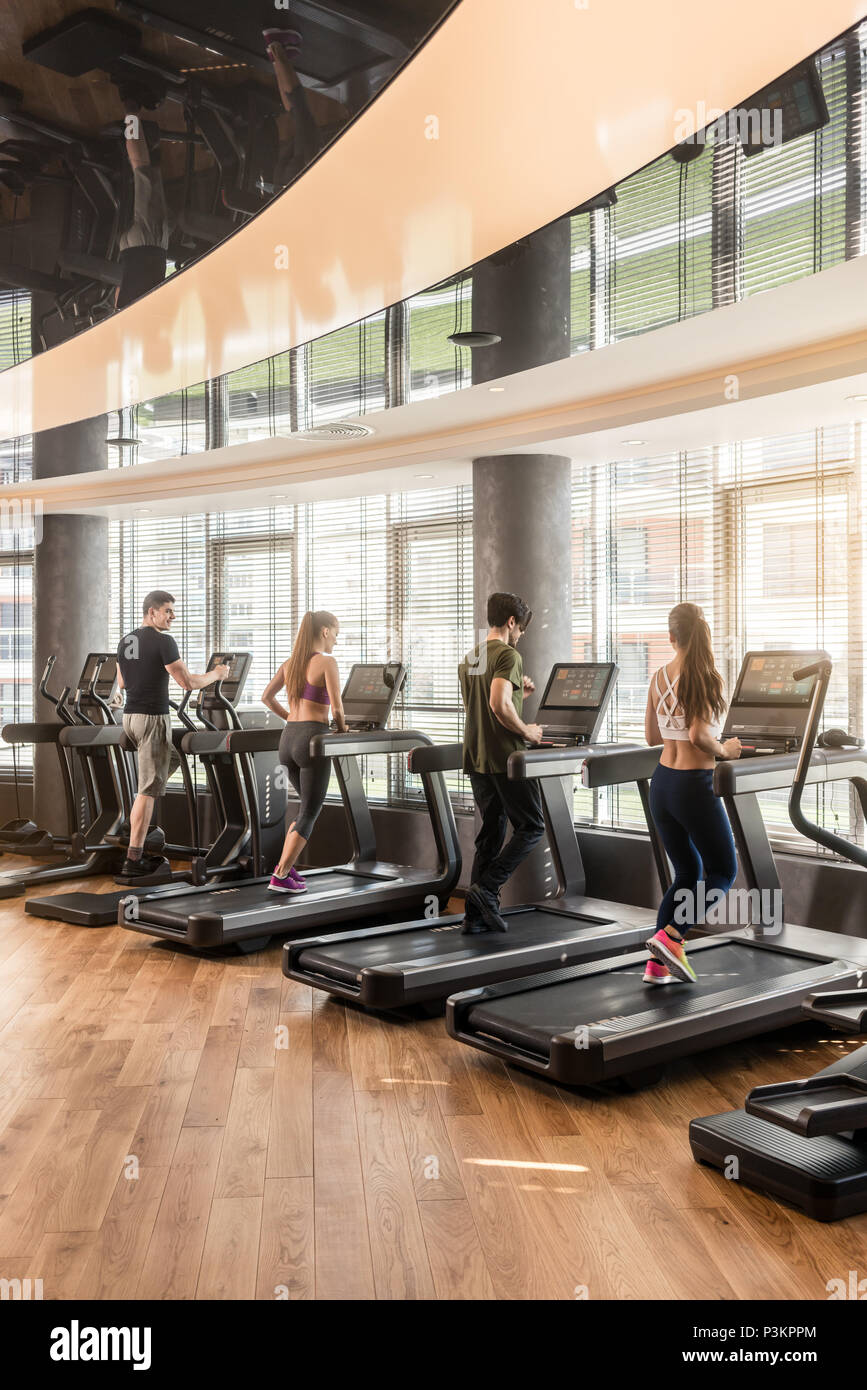Group of four people running on treadmills in fitness gym Stock Photo ...