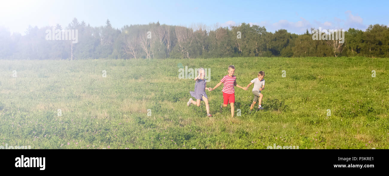 Happy children running in spring field in the daytime Stock Photo - Alamy