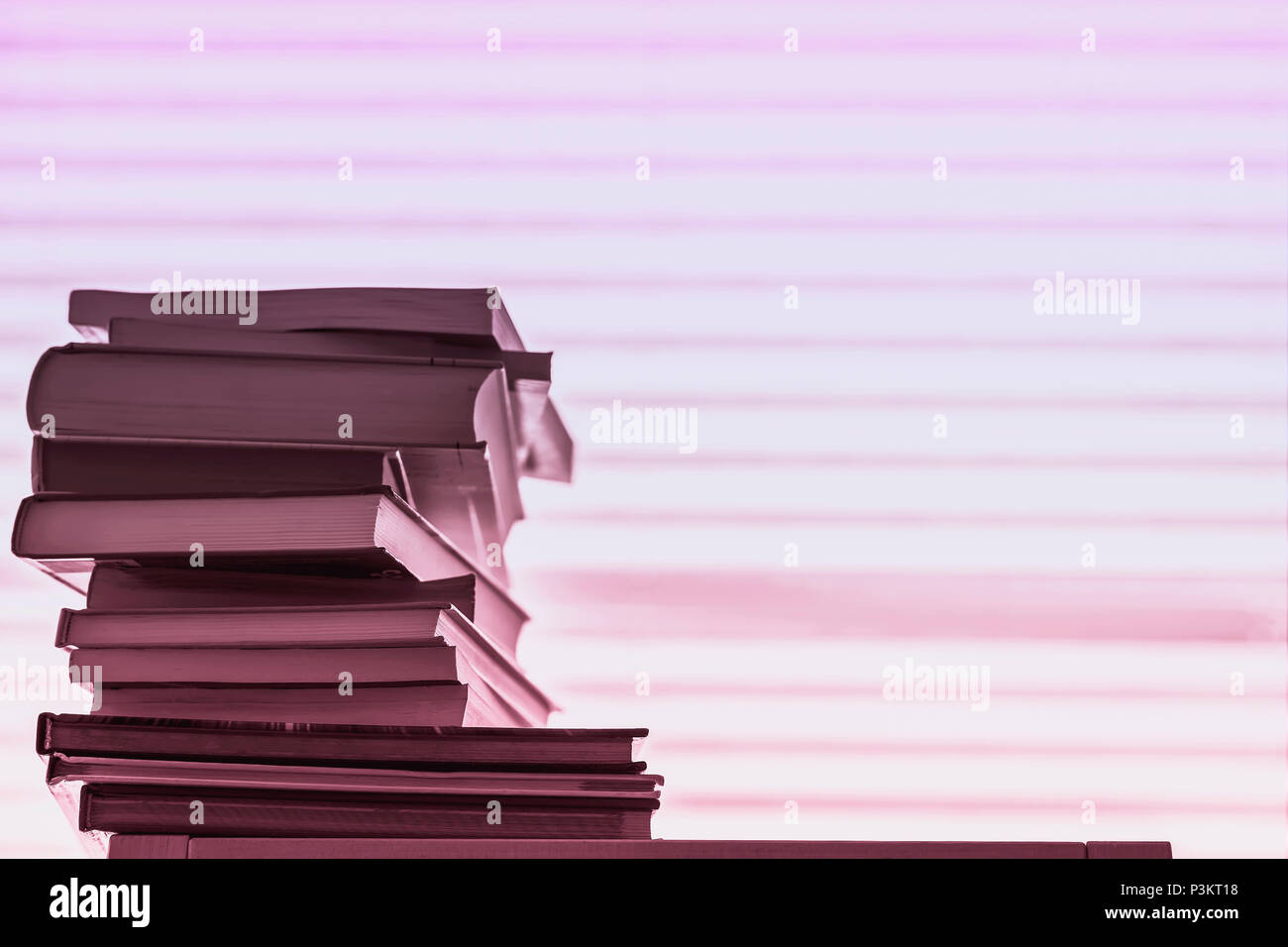 Stack of different books, textbooks against a light striped pink violet ...