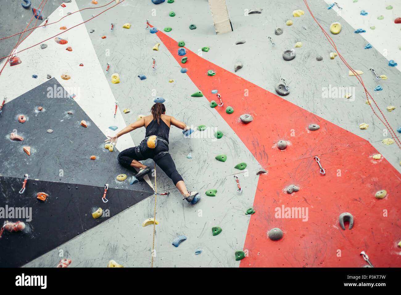 Beautiful young woman taking a big step up an artificial wall Stock ...