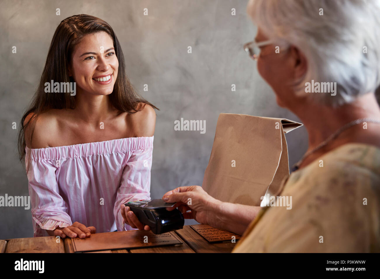 Senior Customer Buying Goods In Store Using Contactless Payment Stock ...