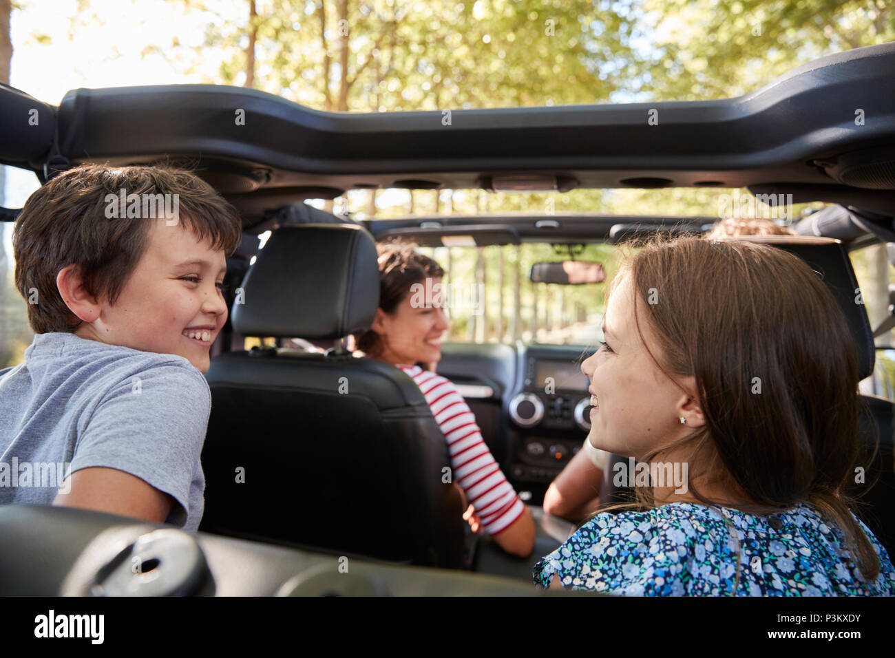 Family Driving In Open Top Car On Countryside Road Trip Stock Photo - Alamy