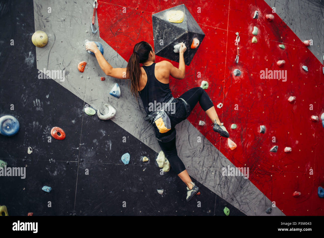 Beautiful young woman taking a big step up an artificial wall Stock ...
