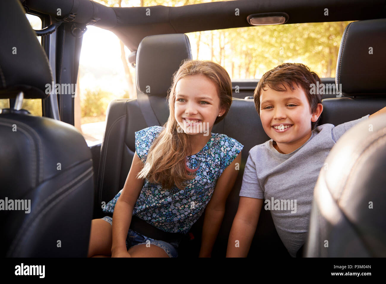 Children Sitting In Back Seat Of Open Top Car On Road Trip Stock Photo Alamy