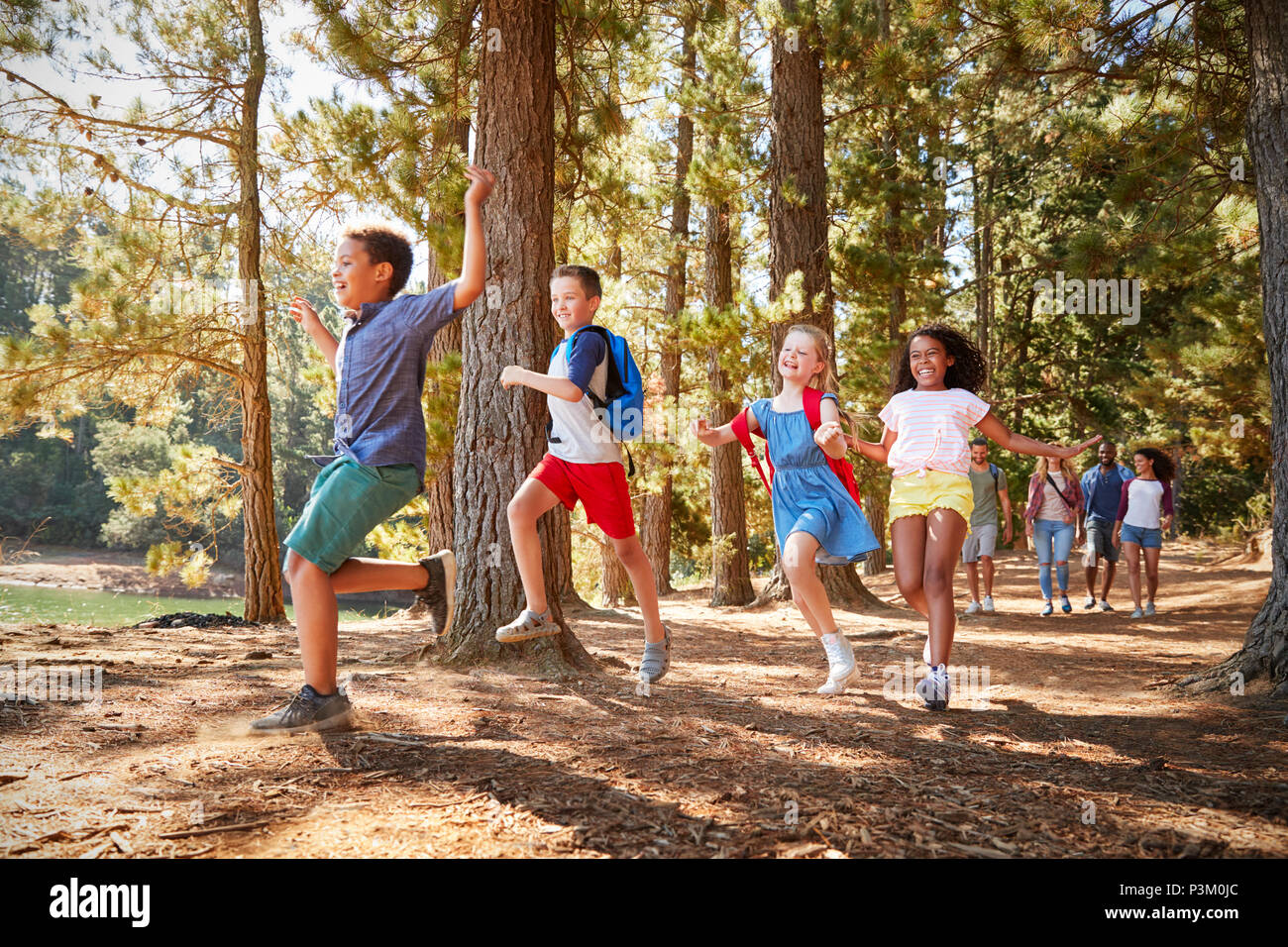 Children Running Ahead Of Parents On Family Hiking Adventure Stock ...
