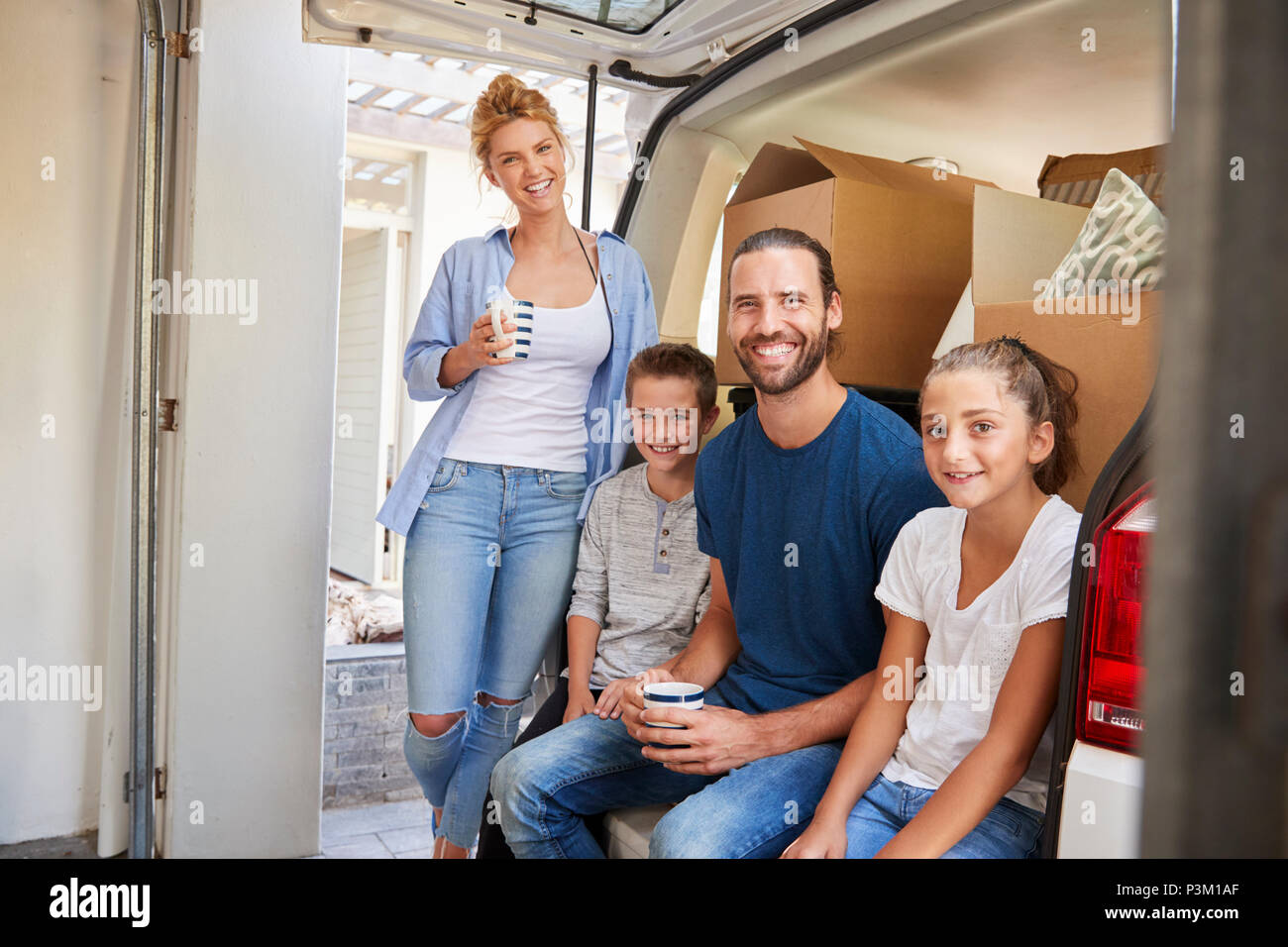 Family Unloading Boxes From Removal Truck On Moving Day Stock Photo - Alamy