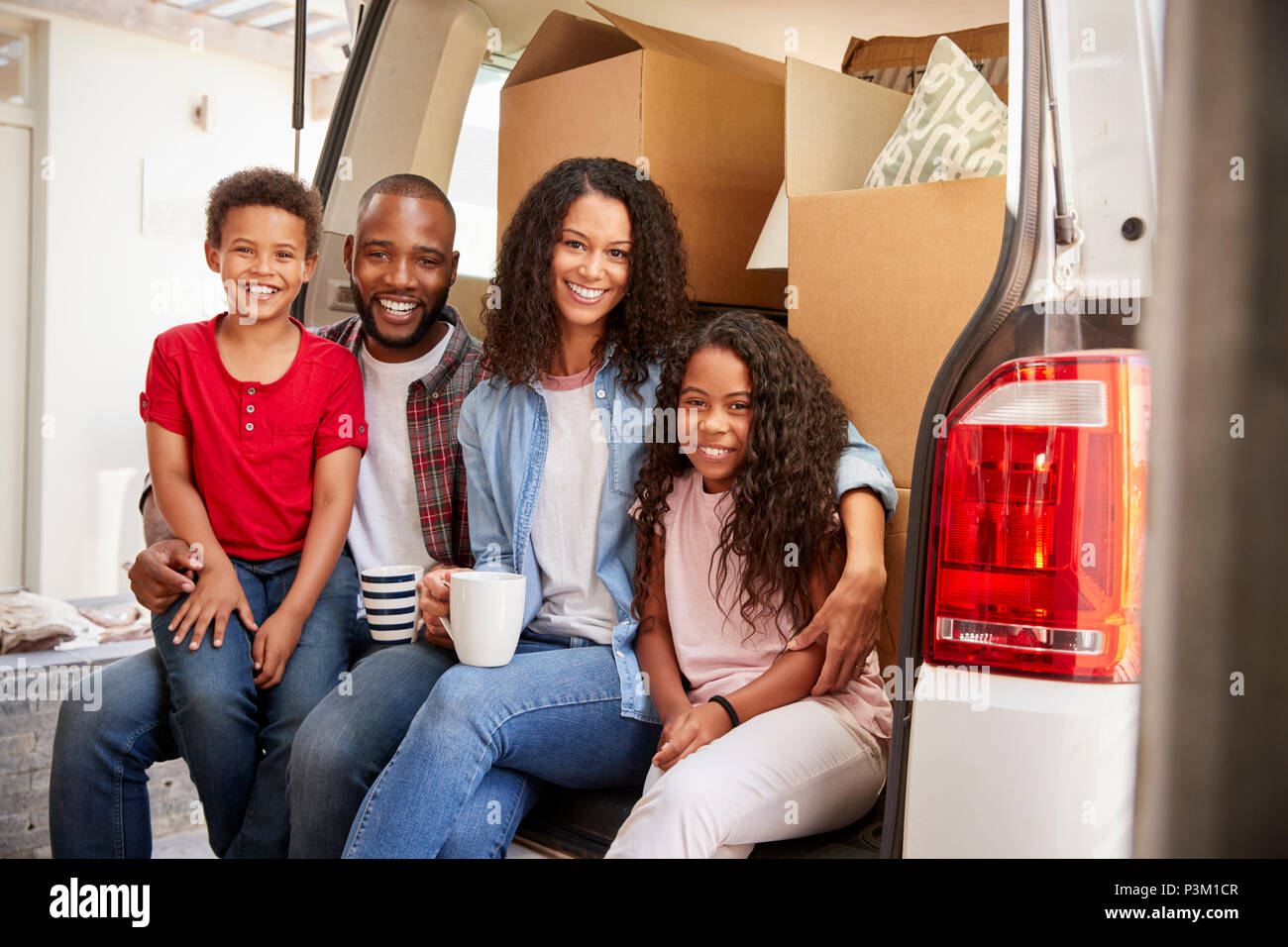 Family Unloading Boxes From Removal Truck On Moving Day Stock Photo - Alamy