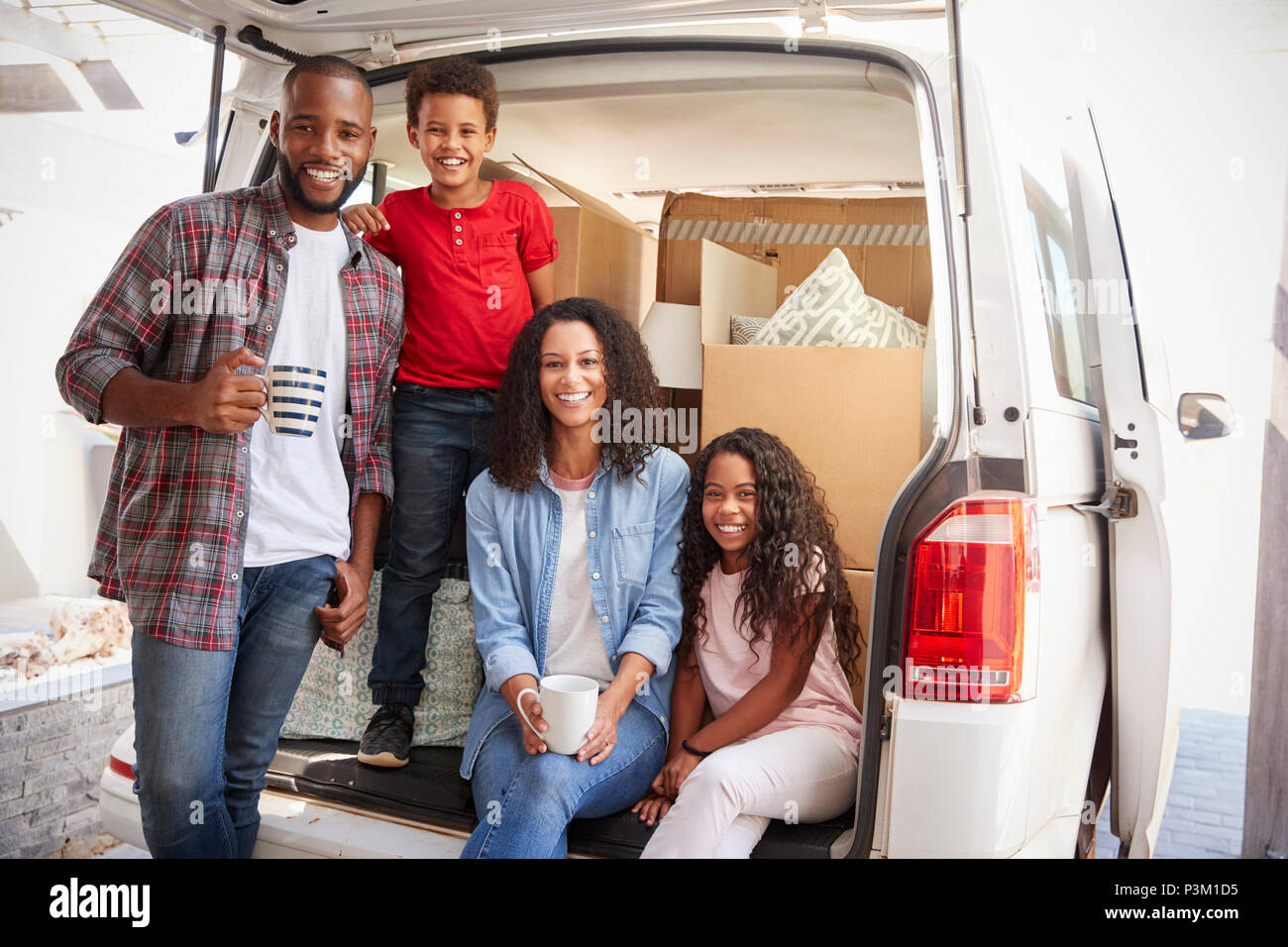 Family Unloading Boxes From Removal Truck On Moving Day Stock Photo - Alamy