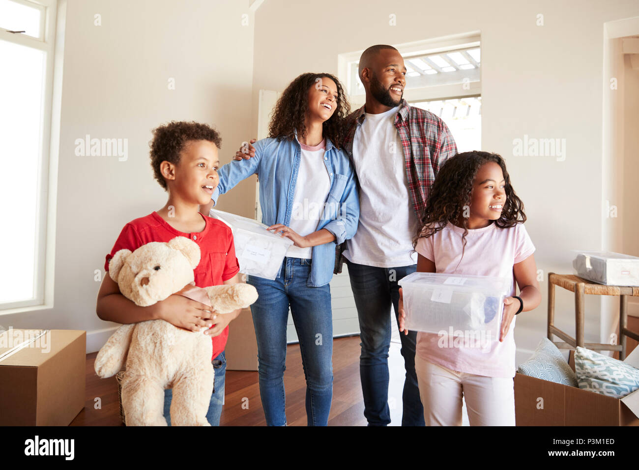 Excited Family Carrying Boxes Into New Home On Moving Day Stock Photo ...