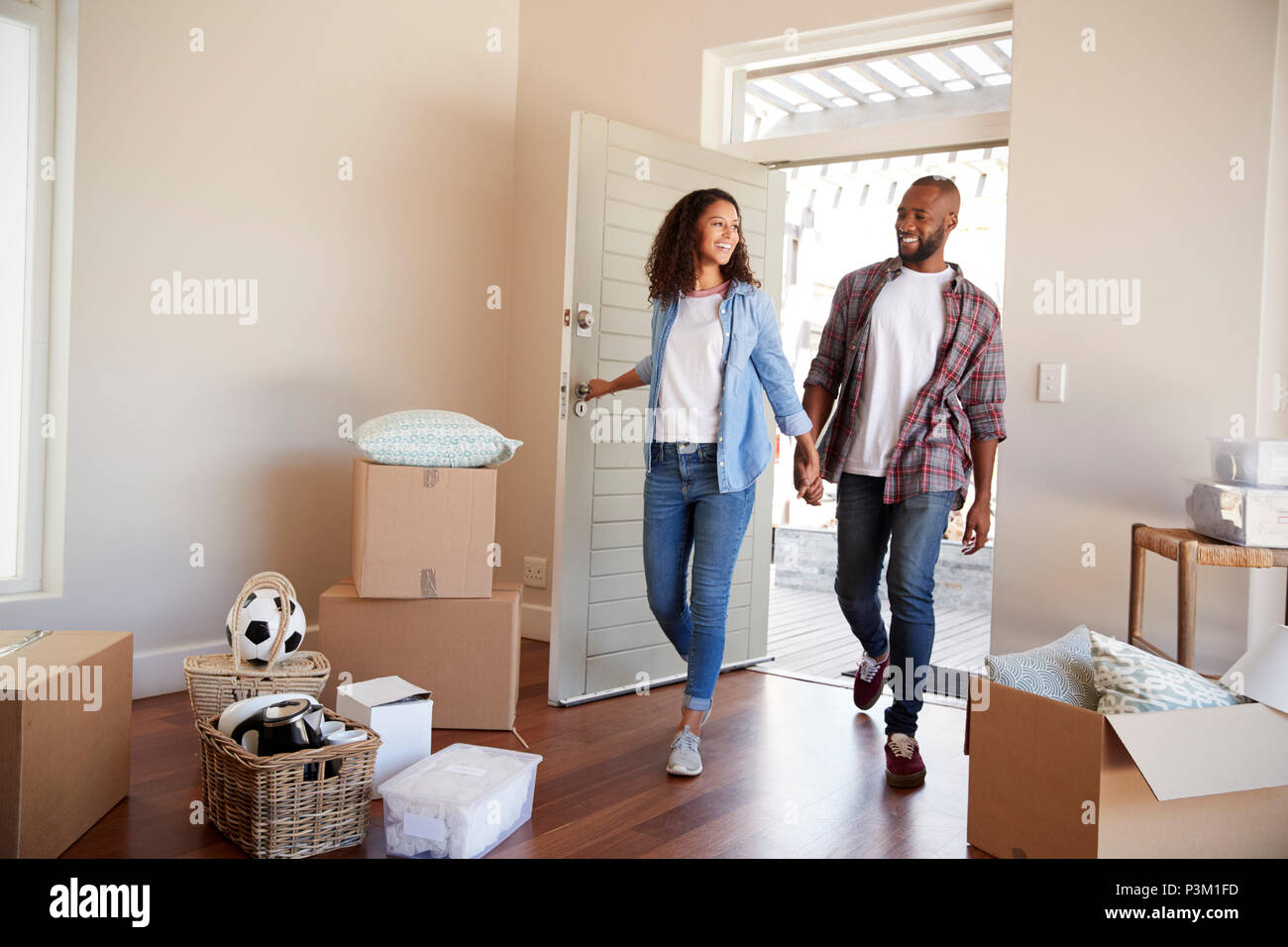 Couple Holding Hands Walk Into New Home On Moving Day Stock Photo - Alamy