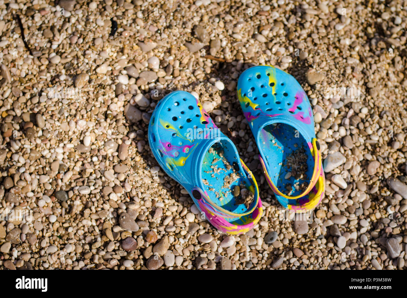 colorful beach blue sandals on rocky beach Stock Photo - Alamy