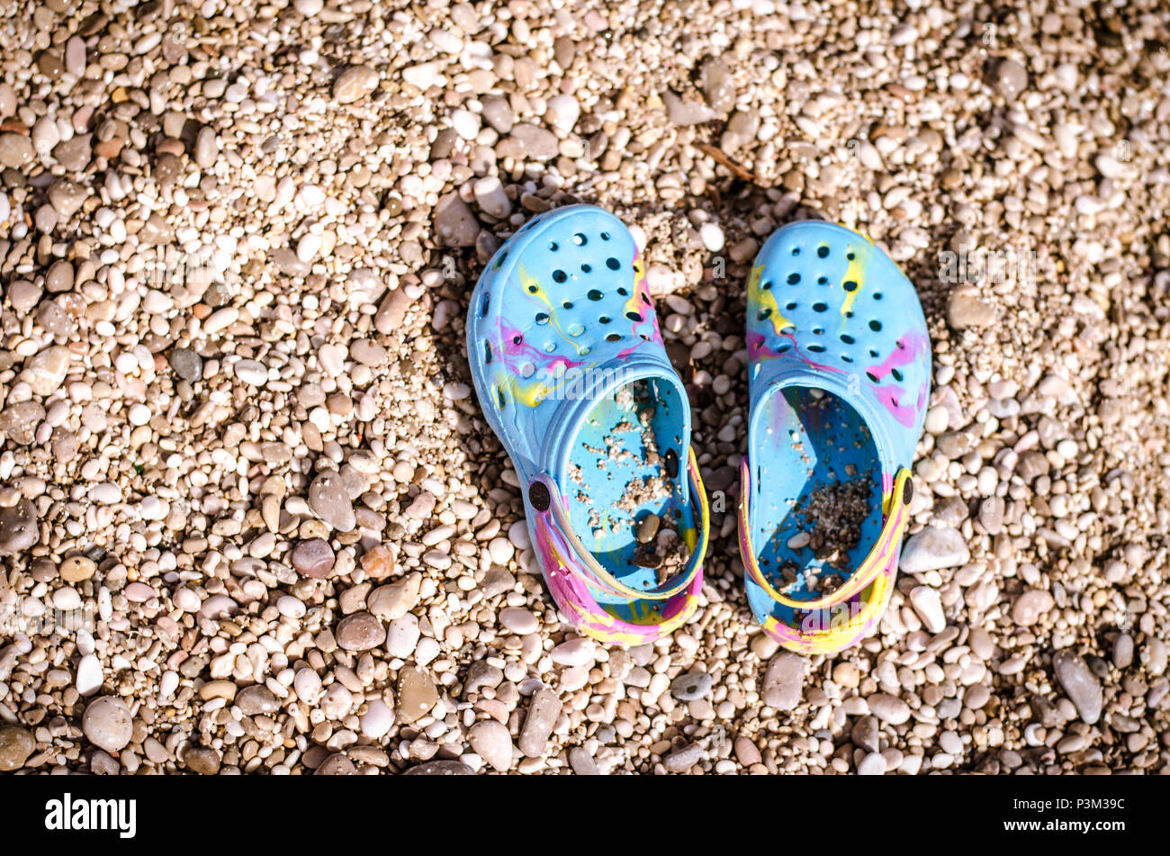 colorful beach blue sandals on rocky beach Stock Photo - Alamy