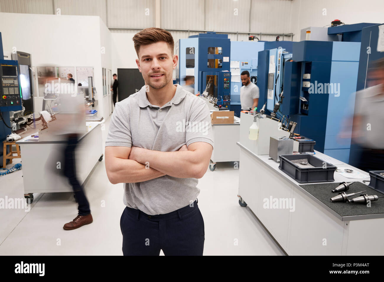 Portrait Of Male Engineer On Factory Floor Of Busy Workshop Stock Photo ...
