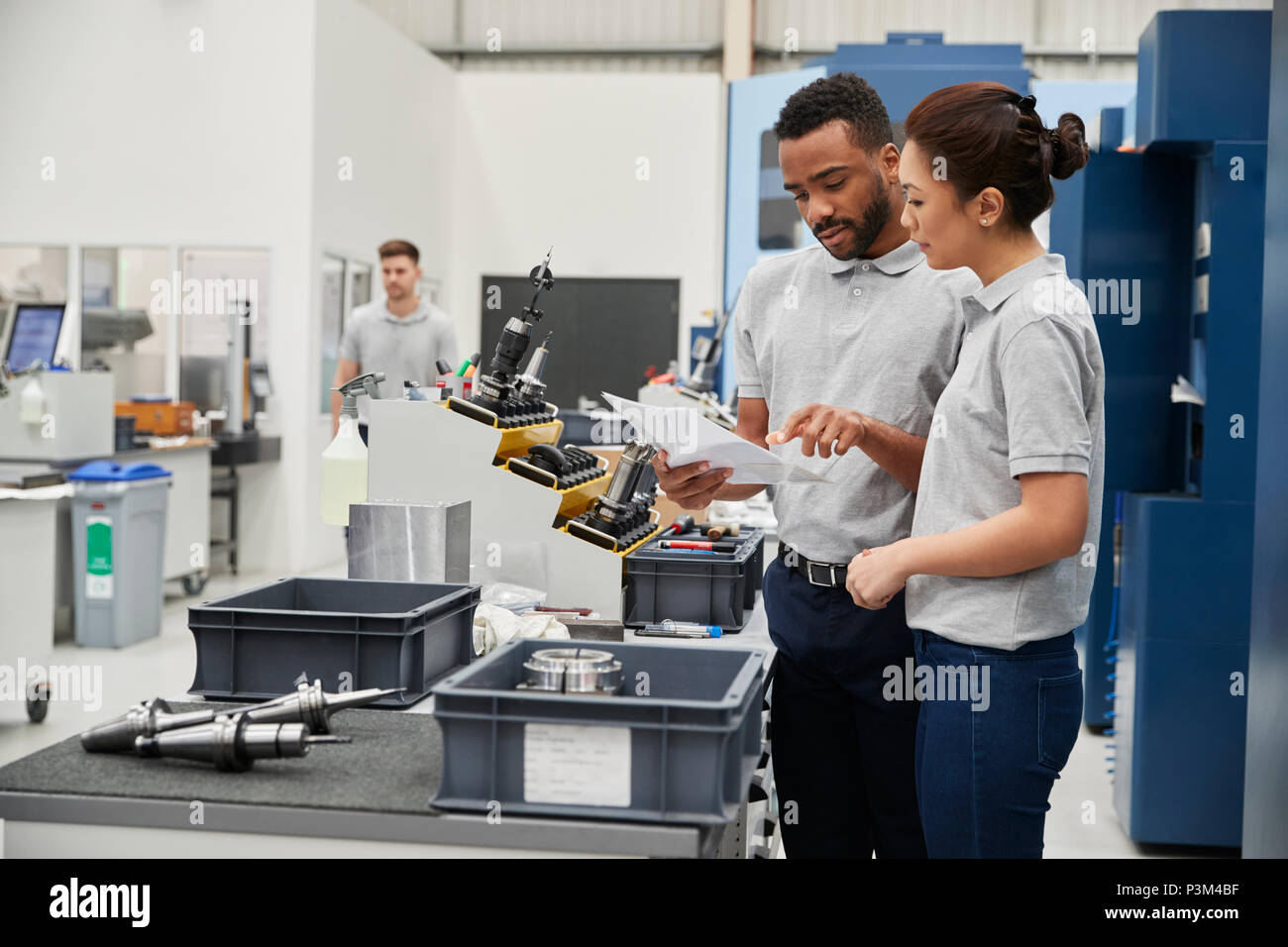 Engineer And Apprentice Meet On Floor Of Engineering Workshop Stock ...