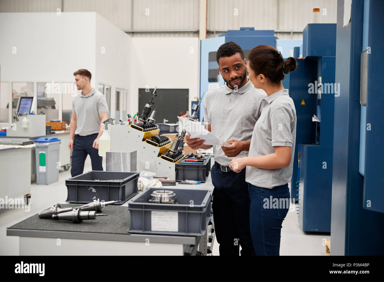 Engineer And Apprentice Meet On Floor Of Engineering Workshop Stock ...