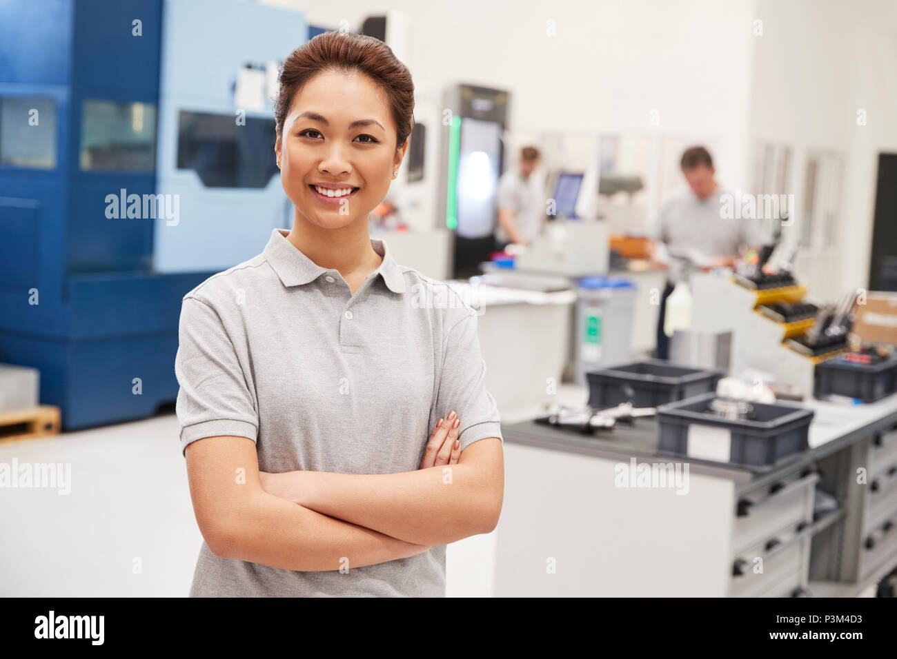 Portrait Of Female Engineer On Factory Floor Of Busy Workshop Stock ...