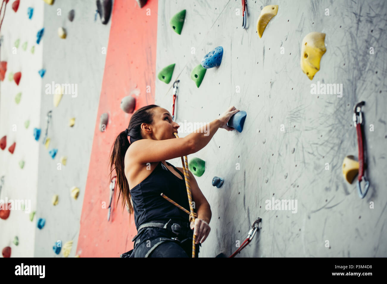 Beautiful young woman taking a big step up an artificial wall Stock ...