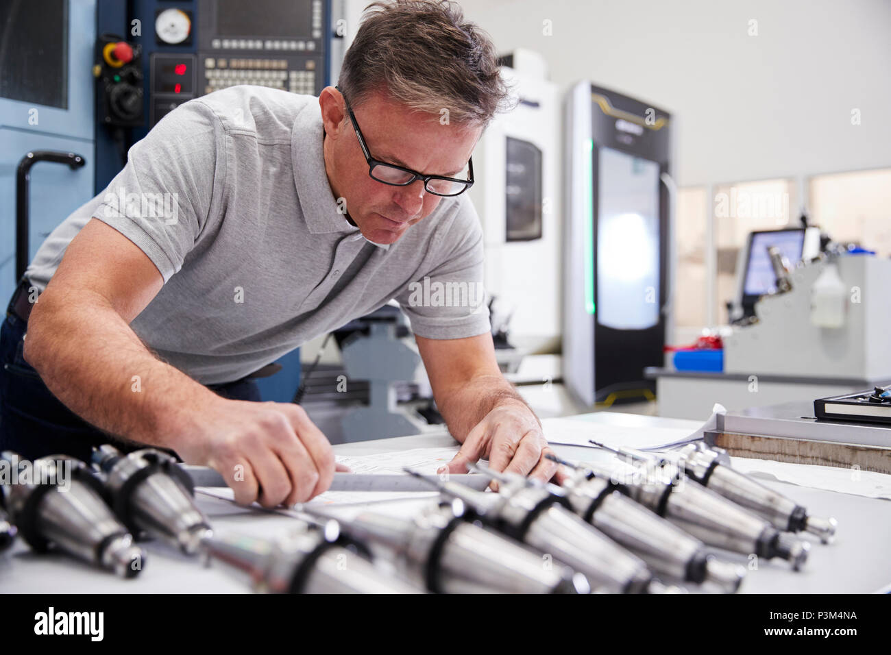 Male Engineer Measuring CAD Drawings In Factory Stock Photo - Alamy