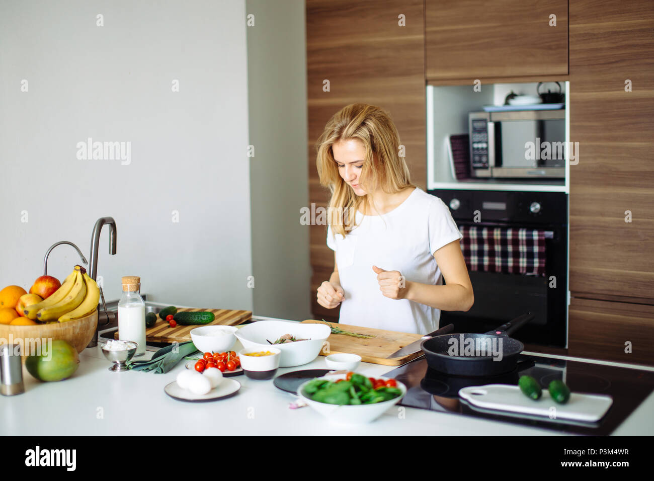 Pleasant young woman preparing dinner in a kitchen concept cooking ...