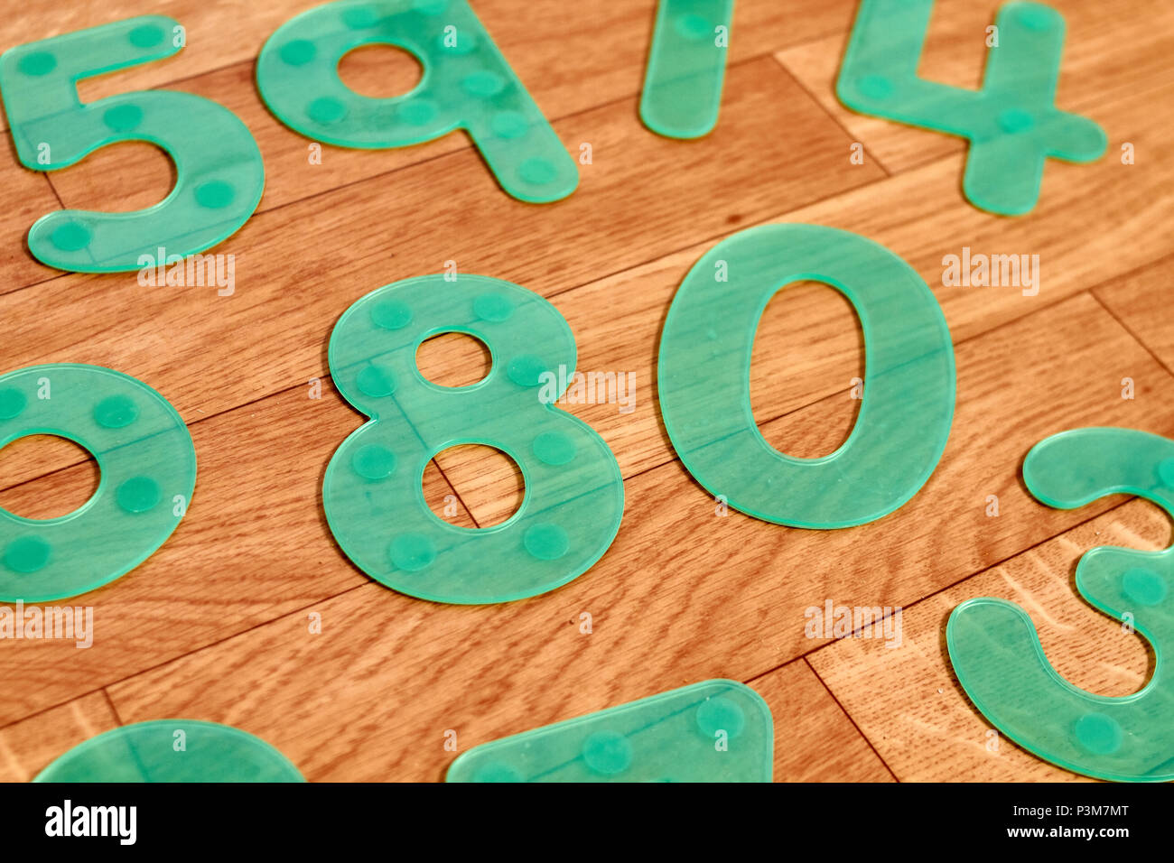 Green numbers on a wooden floor for learning and play Stock Photo - Alamy