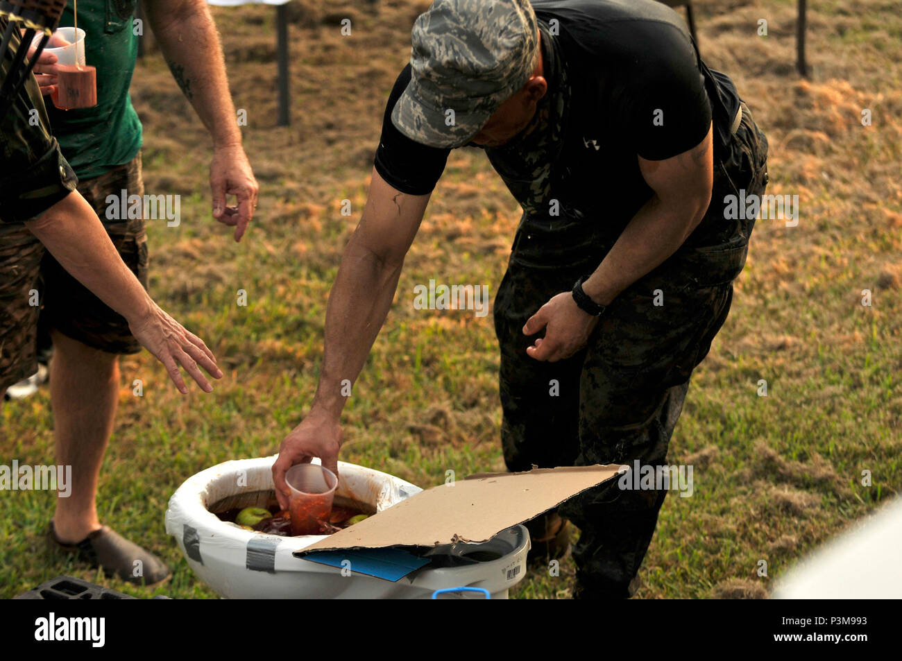 Sergeant At Arms 2nd Lt. David Crupi fishes a cup from the Grog Bowl ...