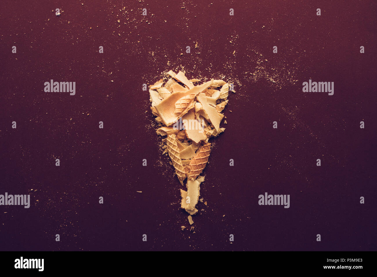 Crushed ice cream cone on dark brown background, flat lay Stock Photo ...