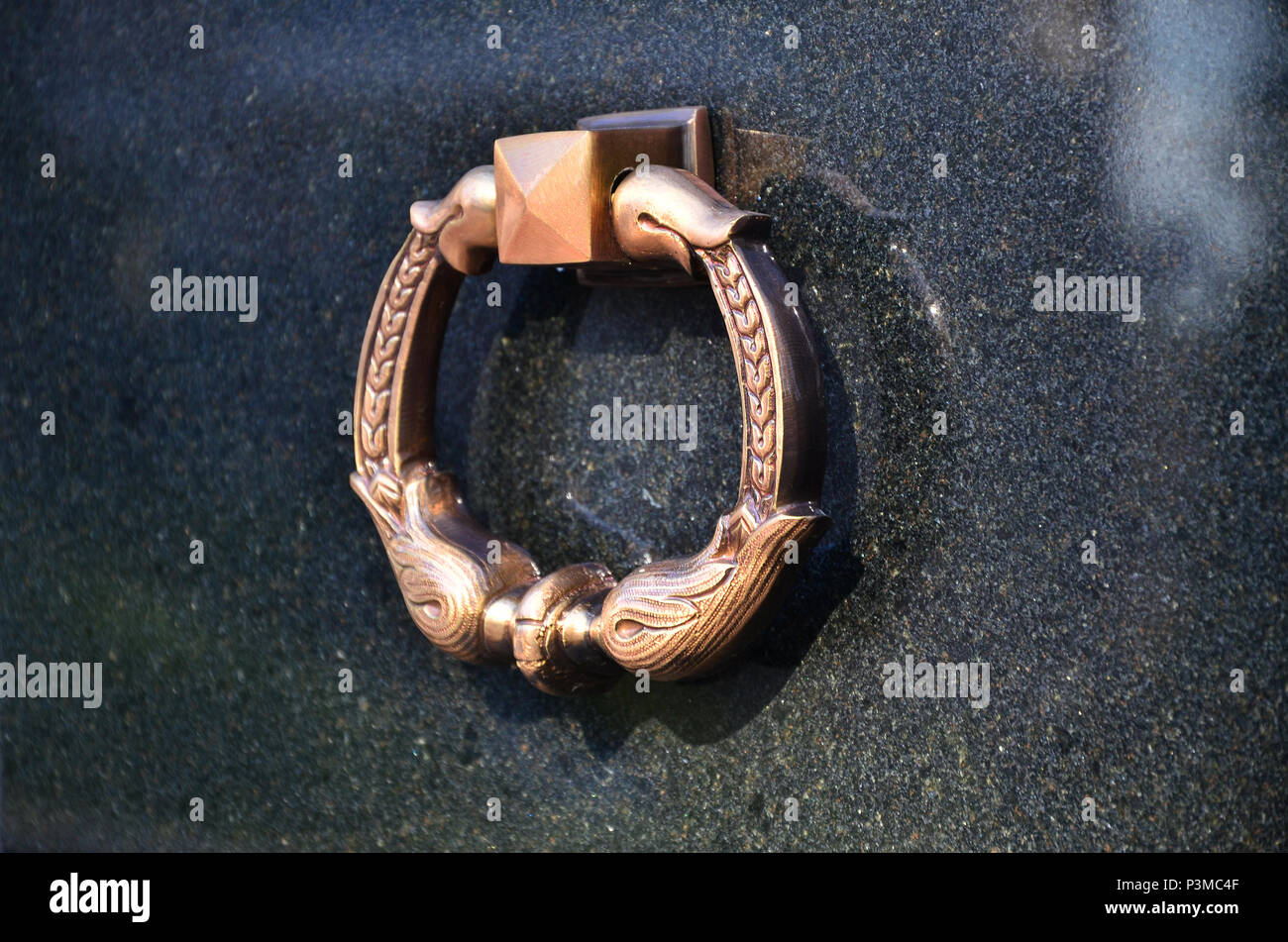 Metal ring on grave of cemetery. Rusty iron handle on granite tomb ...