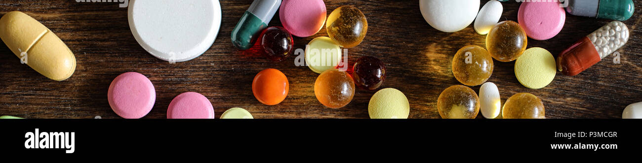 Medical background of various colorful medications on a textured wooden ...