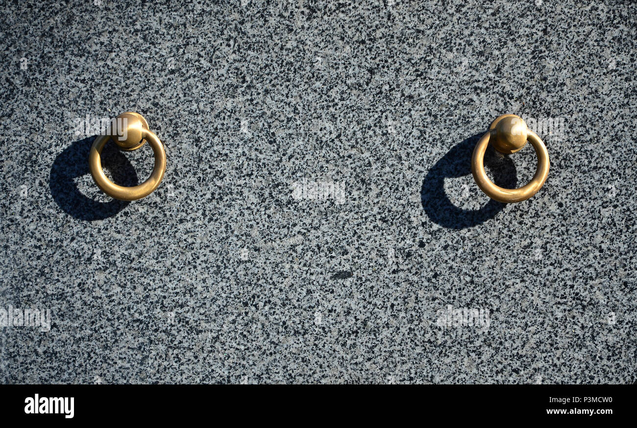 Metal ring on grave of cemetery. Rusty iron handle on granite tomb ...