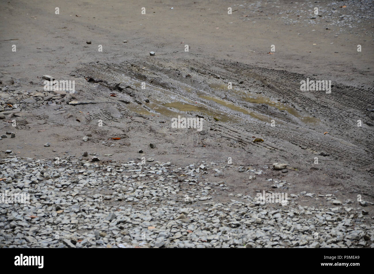 A dirty road with traces of a car driving through the damp ground Stock ...