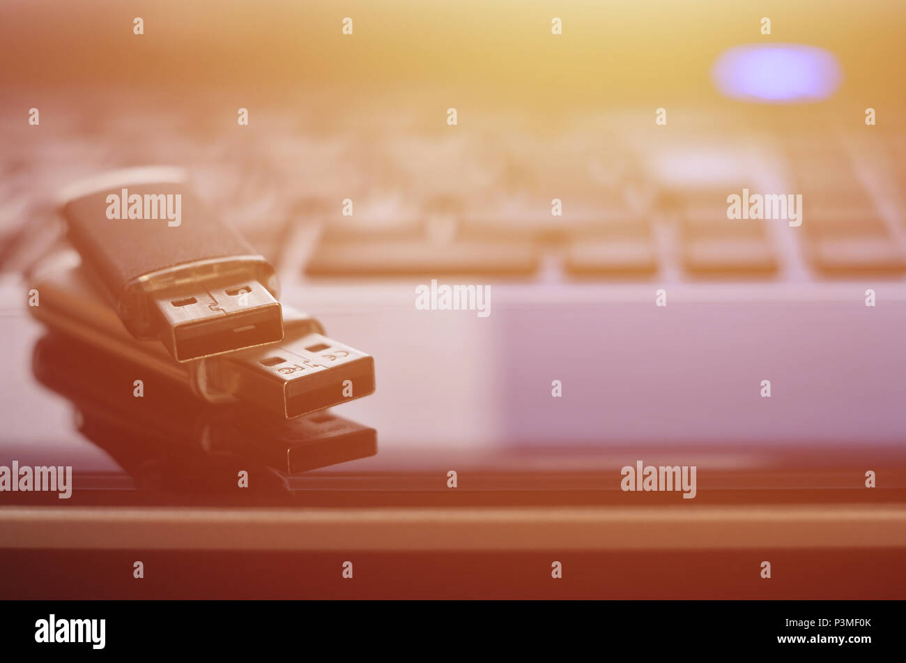 USB flash cards lying on black laptop case in front of his keyboard ...