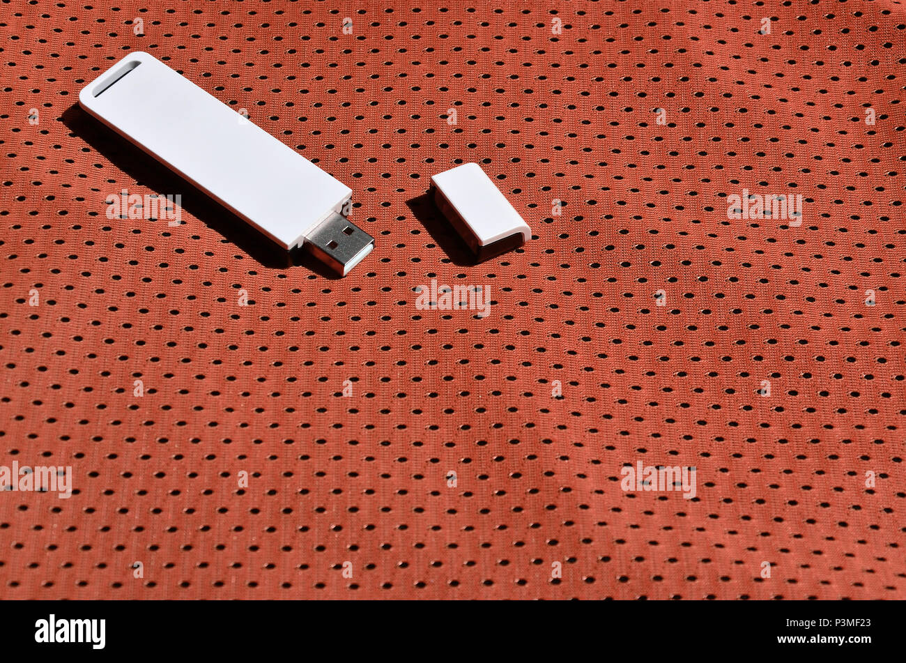 A modern portable USB wi-fi adapter is placed on the red sportswear ... A modern portable USB wi-fi adapter is placed on the red sportswear ...