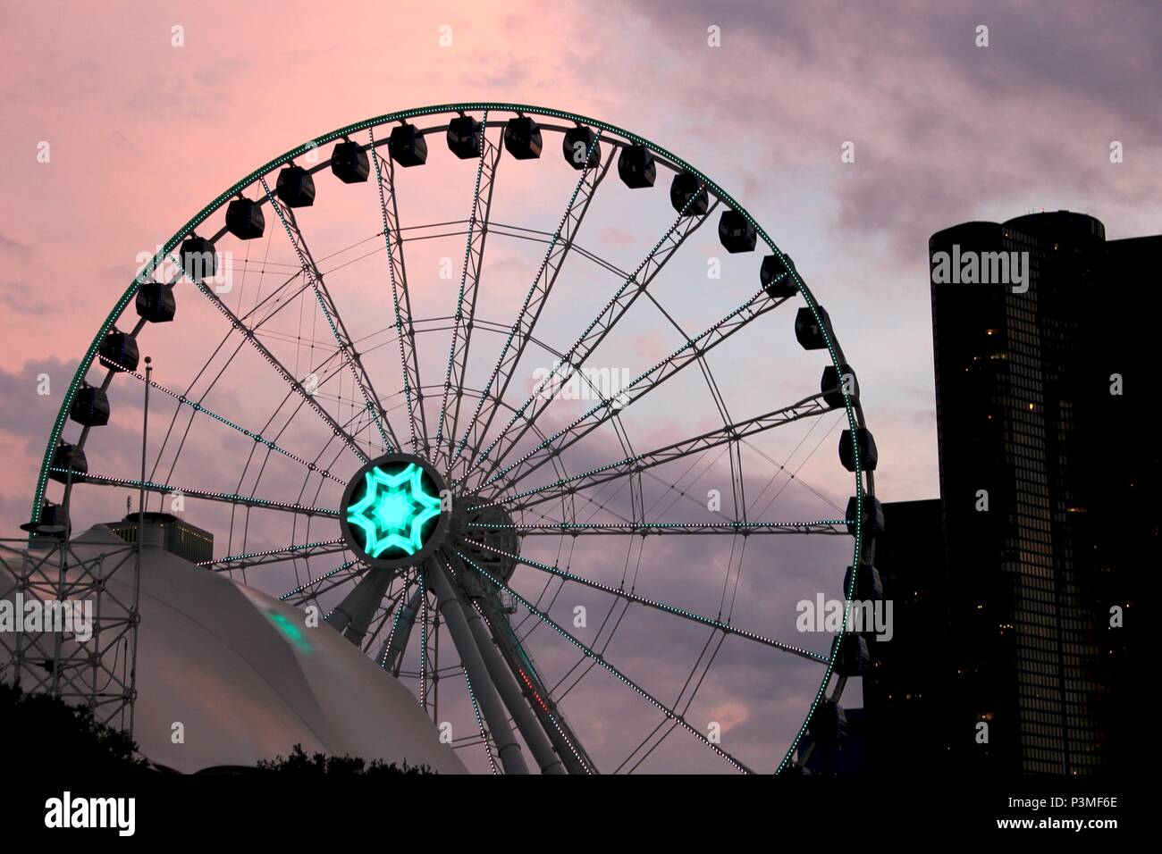 Sun setting behind a ferris wheel Stock Photo - Alamy