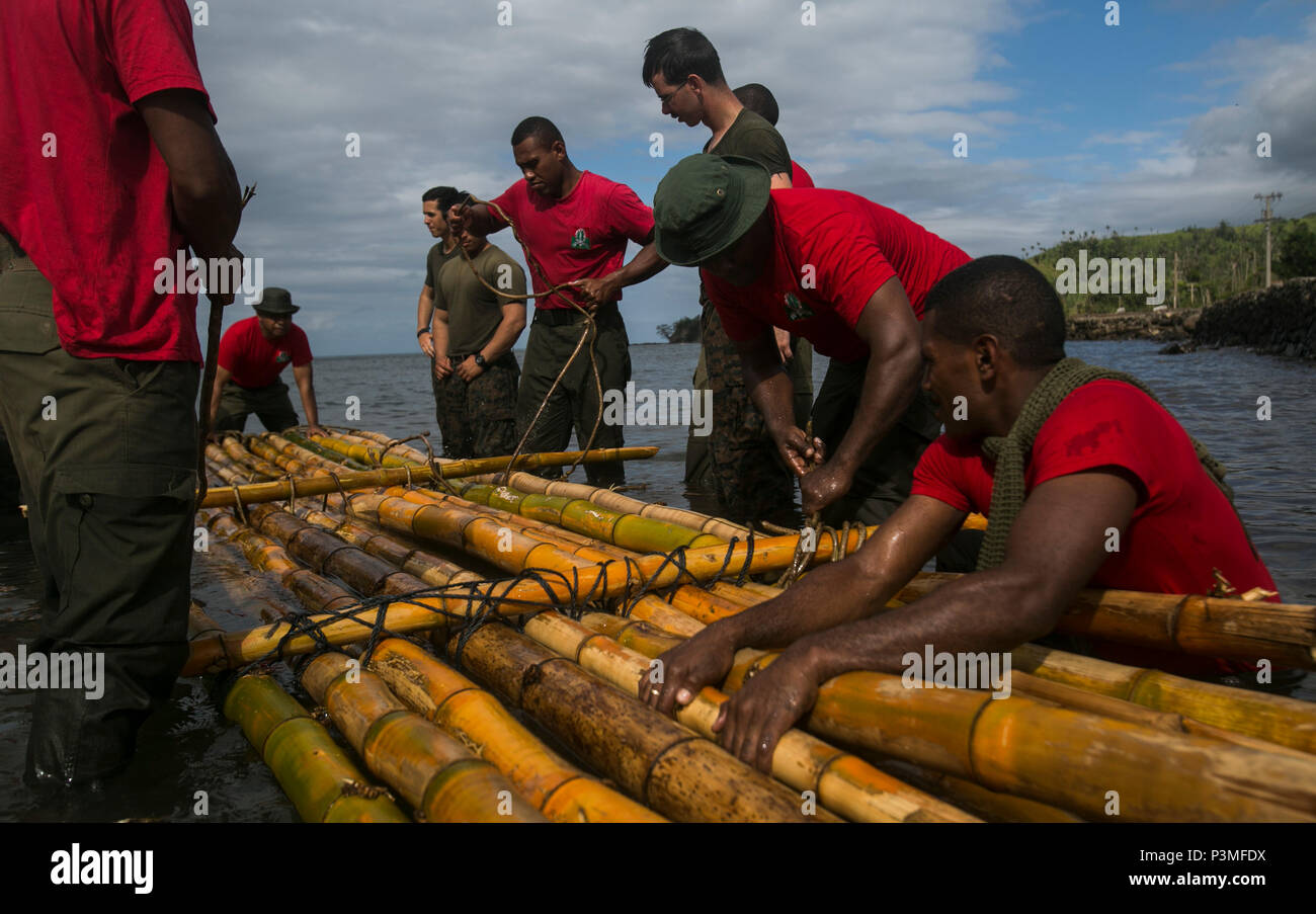 U.S. Marines and Fijian Soldiers work to build a raft from rope and ...