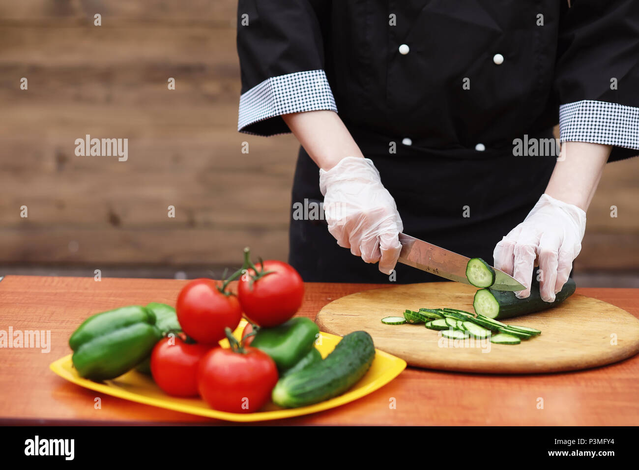 The cook cuts fresh farm vegetables for dinner on the table Stock Photo ...
