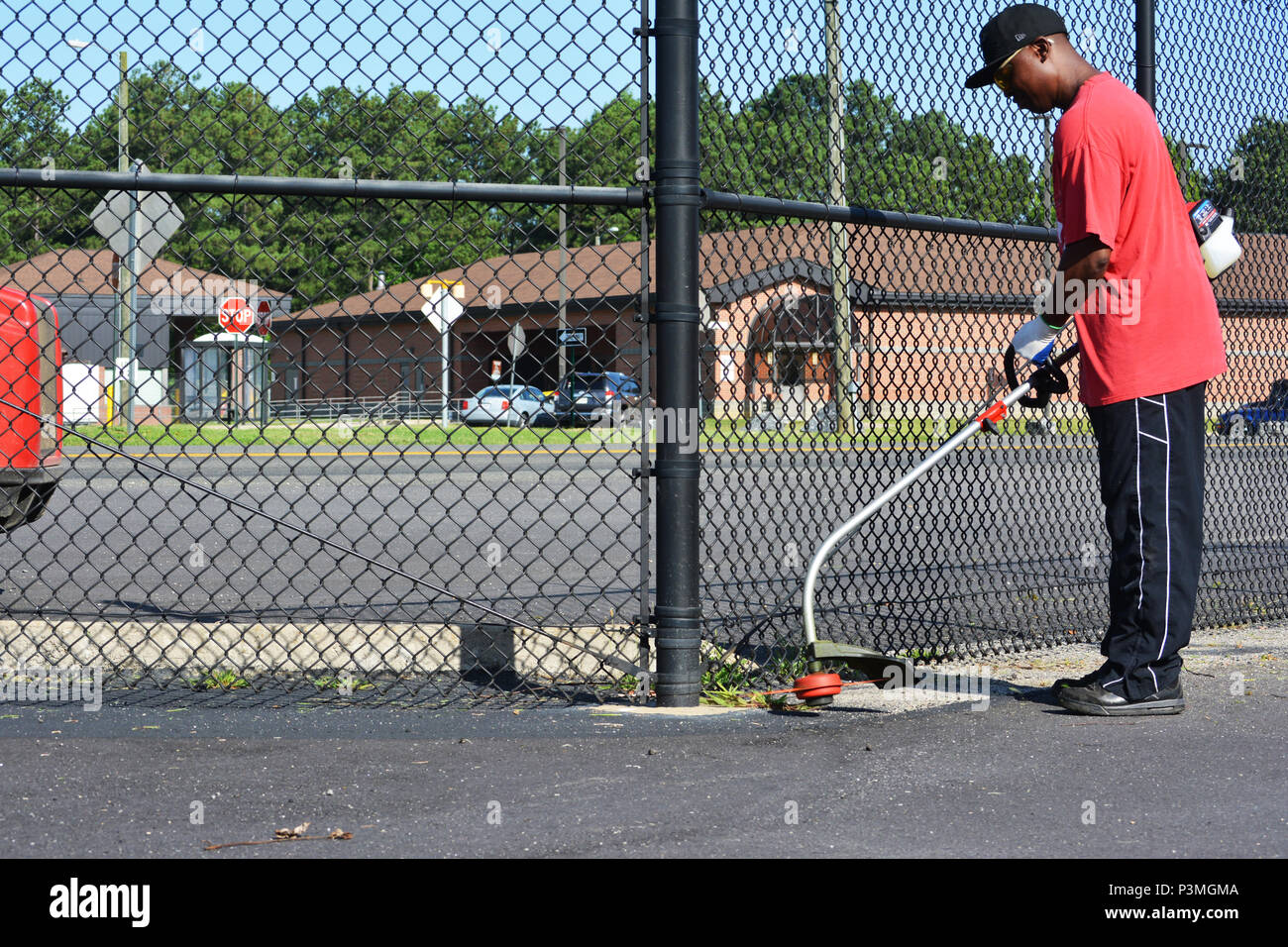 Operates a string trimmer on the headquarters grounds hi-res stock ...