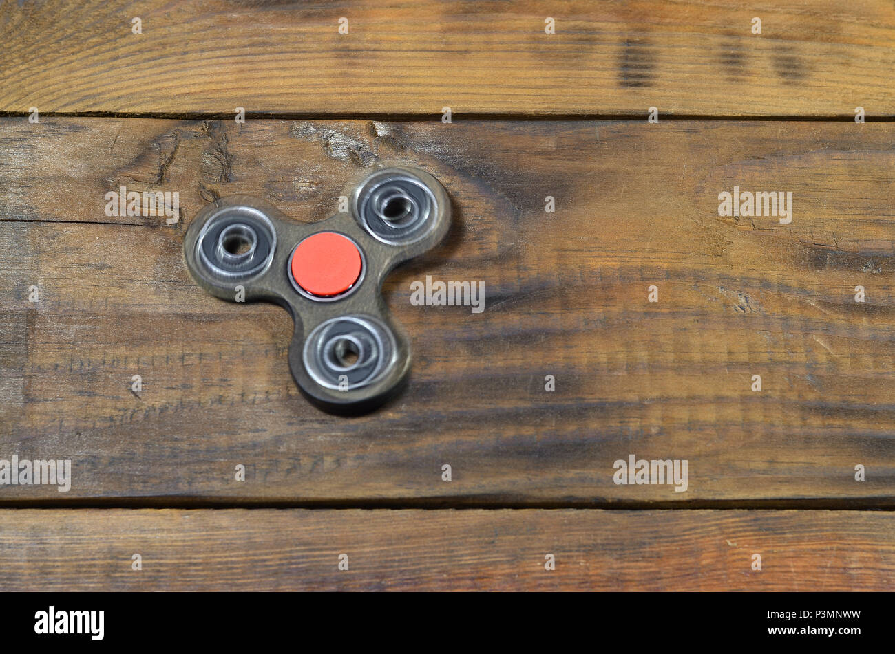 A rare handmade wooden fidget spinner lies on a brown wooden background ...