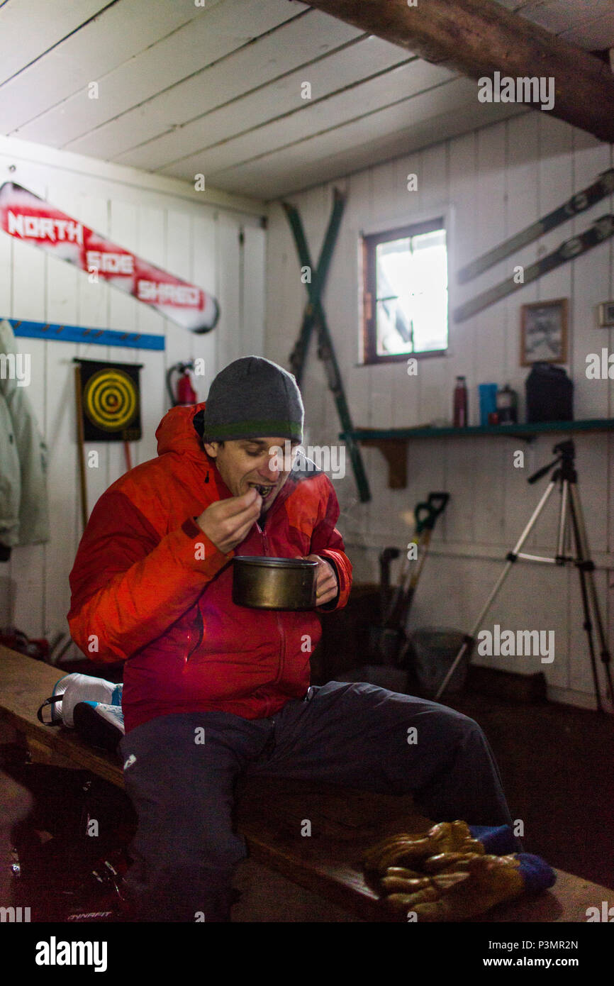 Man eating camp food in backcountry hut on Mt Hood, Oregon, USA Stock ...