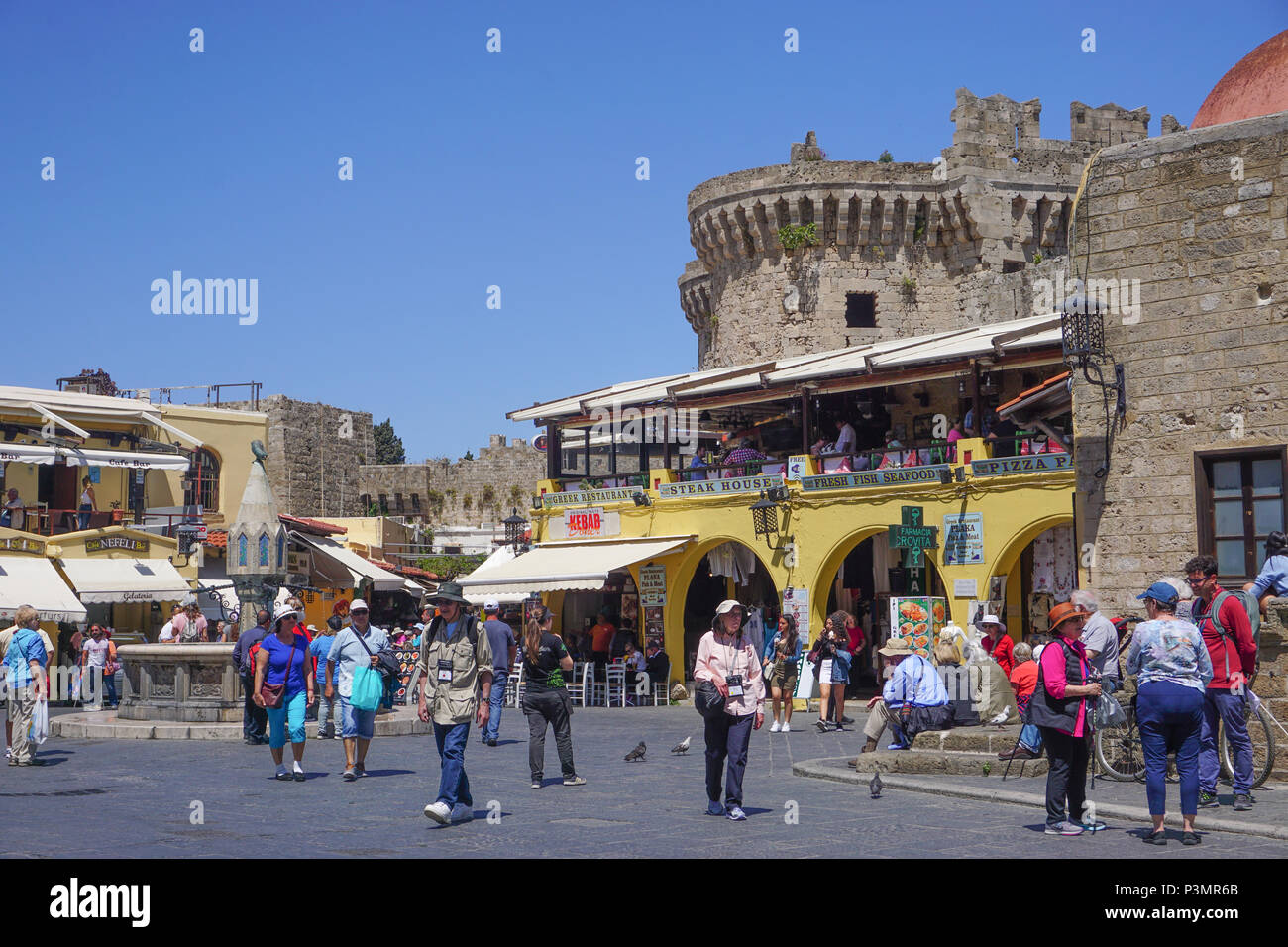 Rhodes, Greece: Tourists in Hippocrates Square beside the towers of the ...